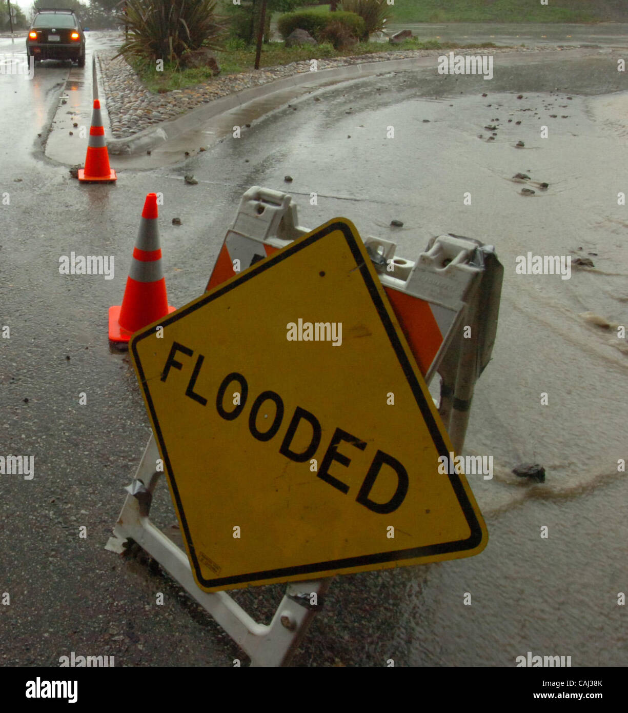 A section of roadway is closed due to flooding after heavy rain and ...