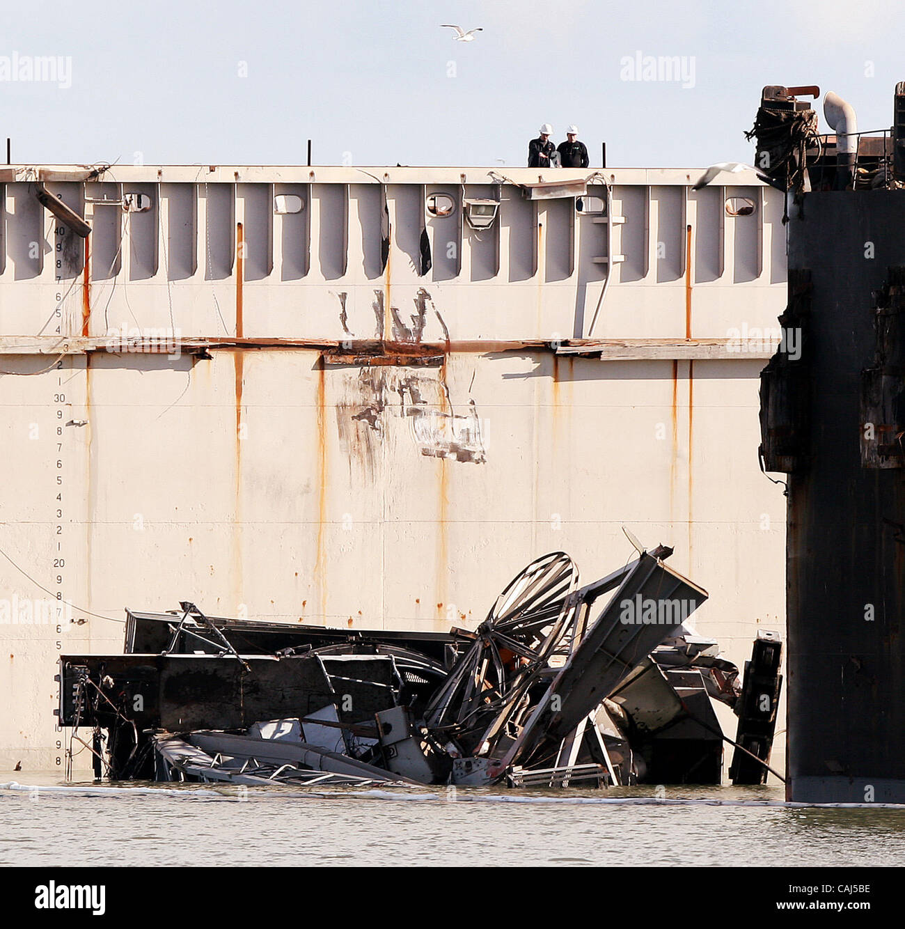 Workers survey the scene of a crane collapse off a dry dock at pier 70 ...