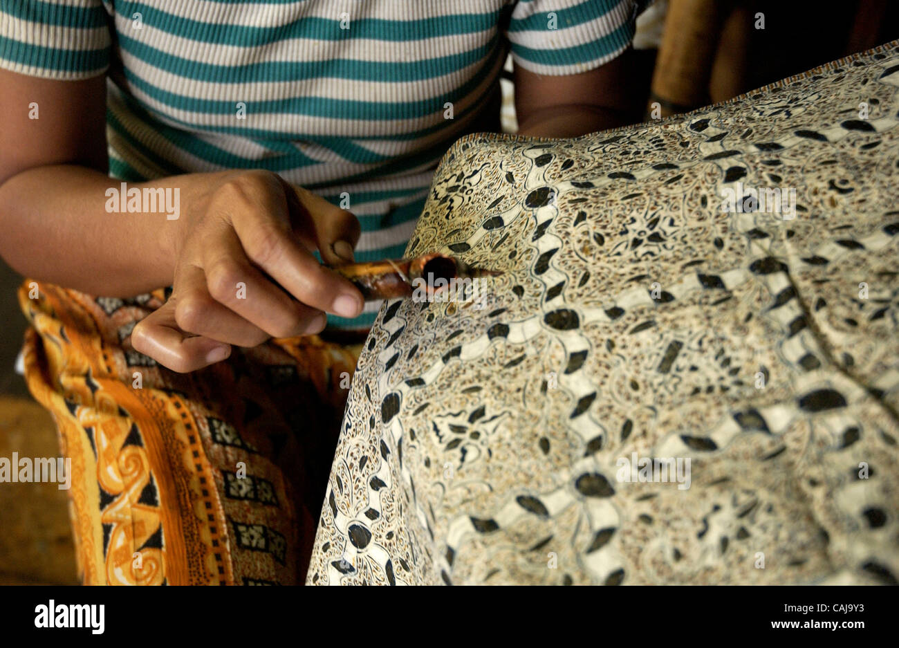 SOLO, CENTRAL JAVA, INDONESIA-JANUARY 13, 2008 A batik worker with a ...
