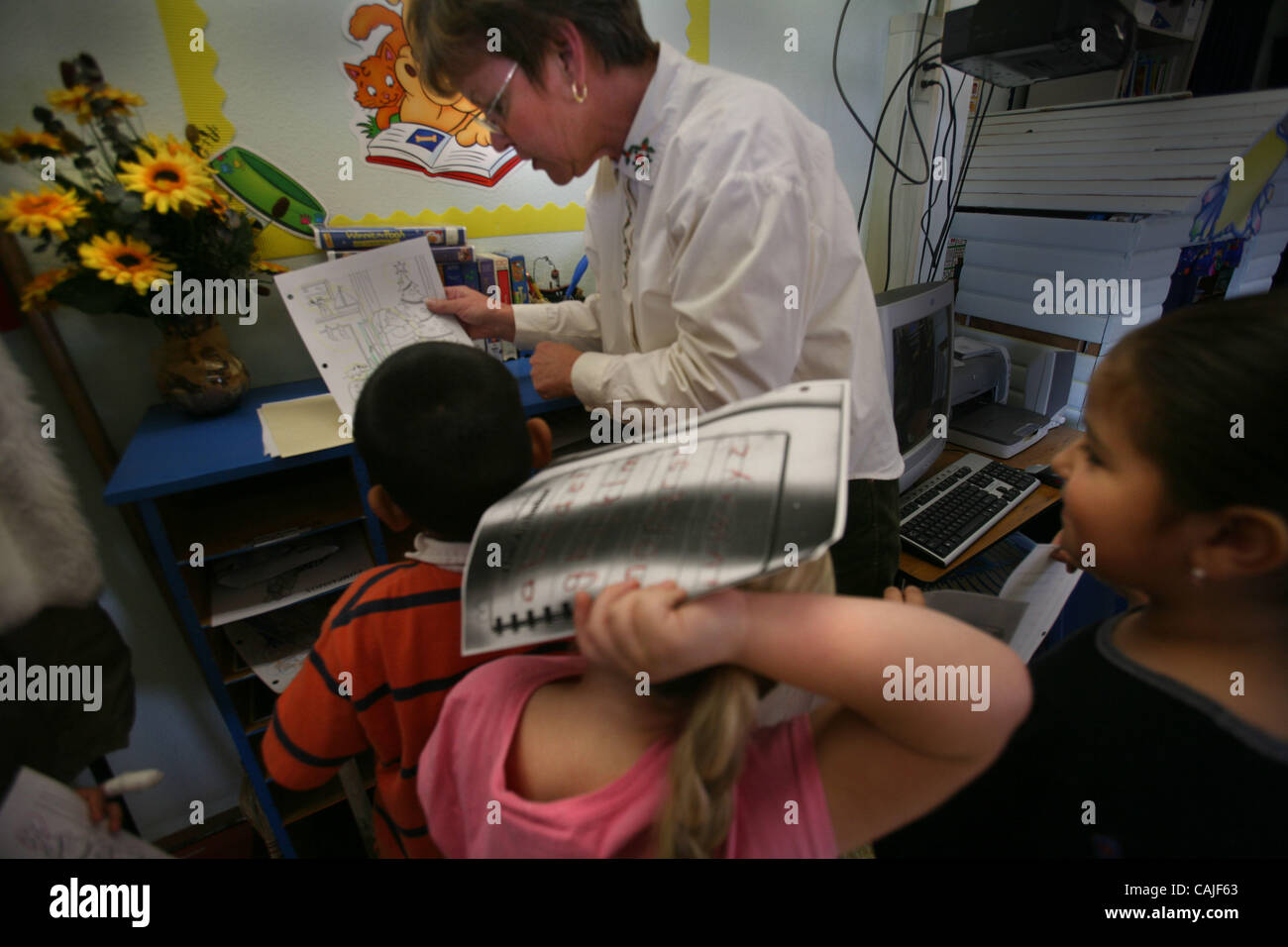 SECOND - Children hand over work papers to teacher Kathy Cahouette in a ...