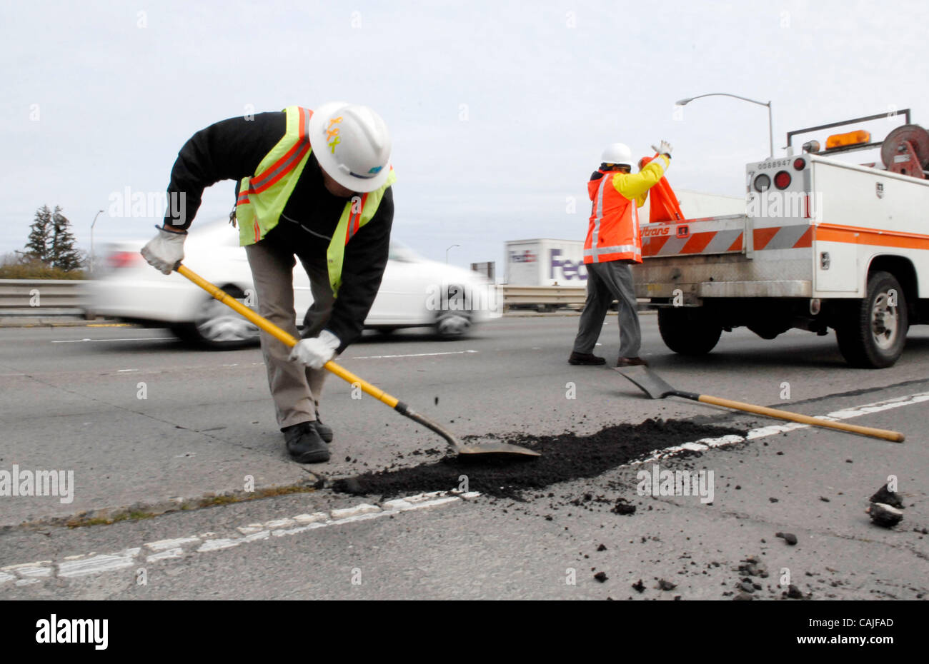 LEDE From left, Caltrans workers Rick Chavez and Gurpreet Singh fill a ...