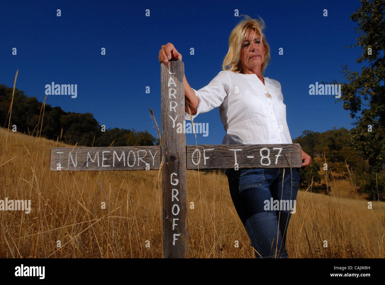 Christine Groff poses next to a cross in at the site where her husband ...