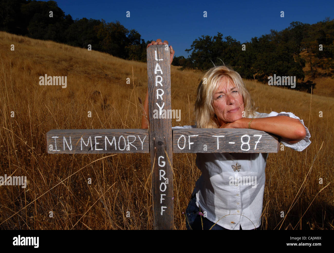 Christine Groff poses next to a cross at the site where her husband ...