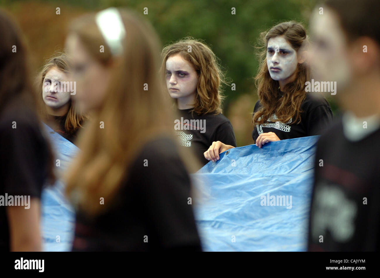 Ashen faced participants prepare to remove the tarp to reveal a car ...