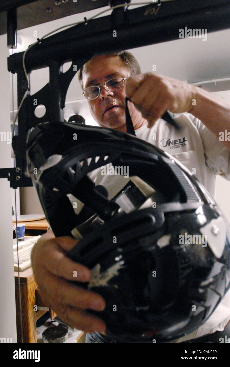 Engineering technician Allen Harris secures a motorcycle helmet to a ...
