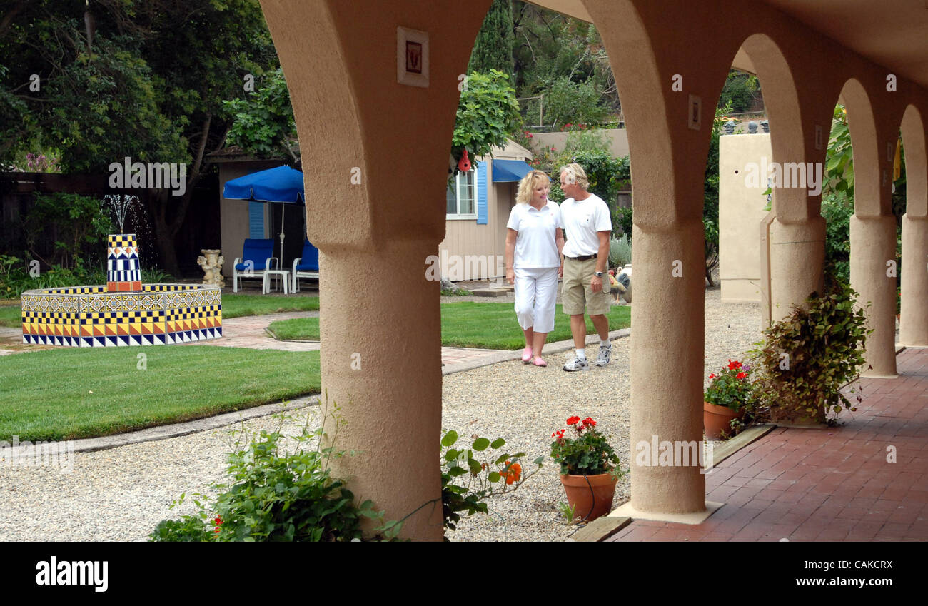 Framed by patio arches, Sandy Scranton and Dale Charon walk together ...