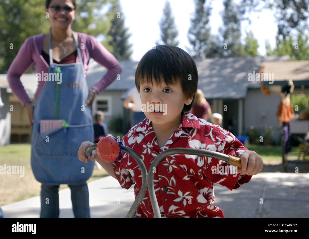 Liezel Rich (cq, left) watches her son Connor Rich (cq), 3, ride a ...