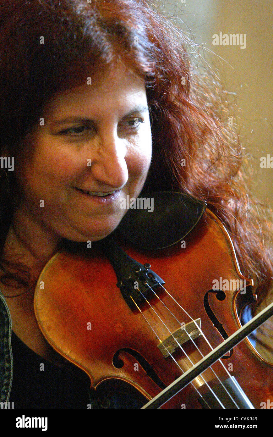 Suzy Thompson plays fiddle during a jam session with friends at her ...