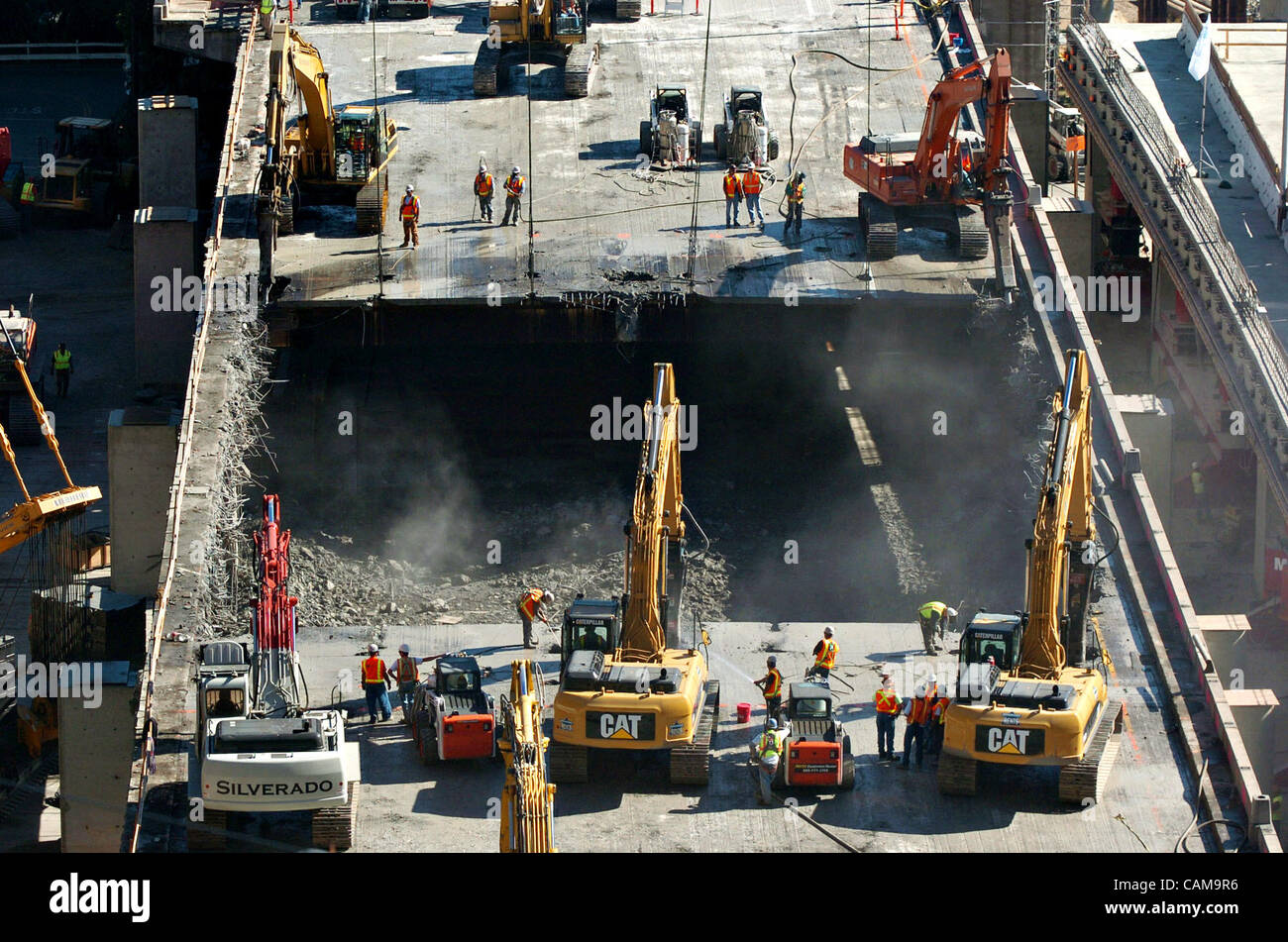 Construction workers for CC Myers Inc. demolish a section of the Bay ...