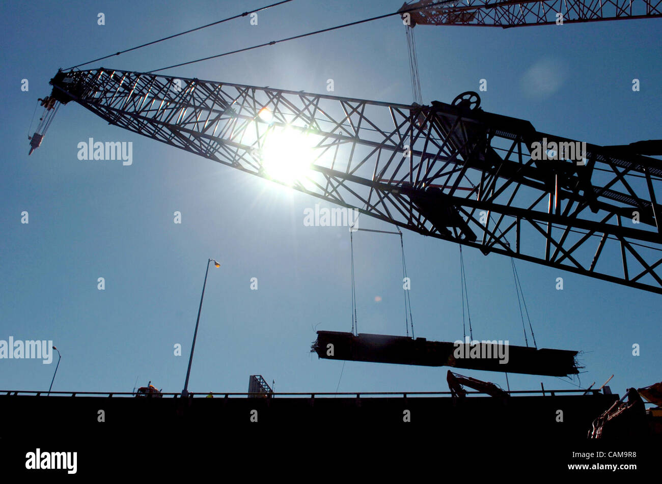 Construction workers for CC Myers Inc. using a crane lift a transversal ...