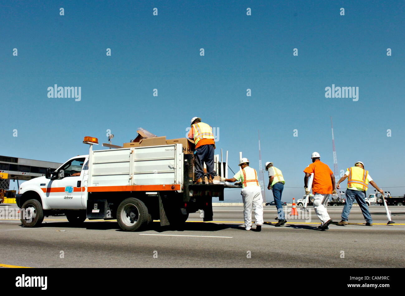 Caltrans workers replace the lane dividers at the Bay Bridge toll plaza ...