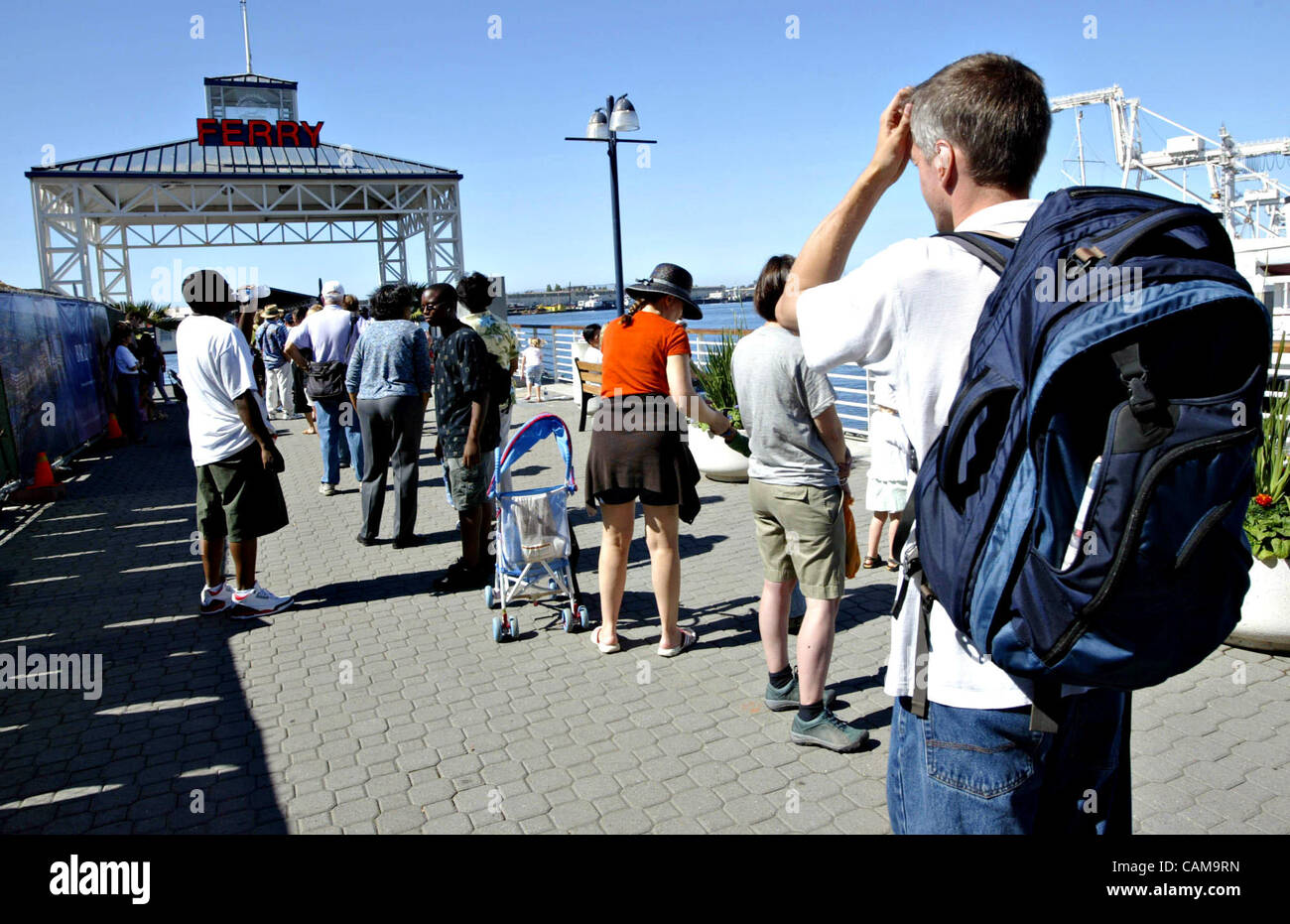 Passengers line up for the 11:00am ferry to San Francisco at the dock ...