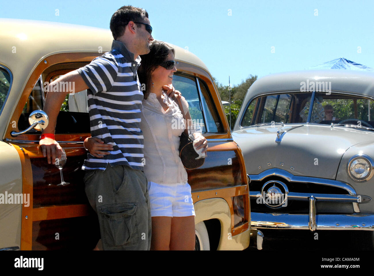 Rob Lembo and Nicloe Buono pose for a photo next to a pair of 1949 Ford ...