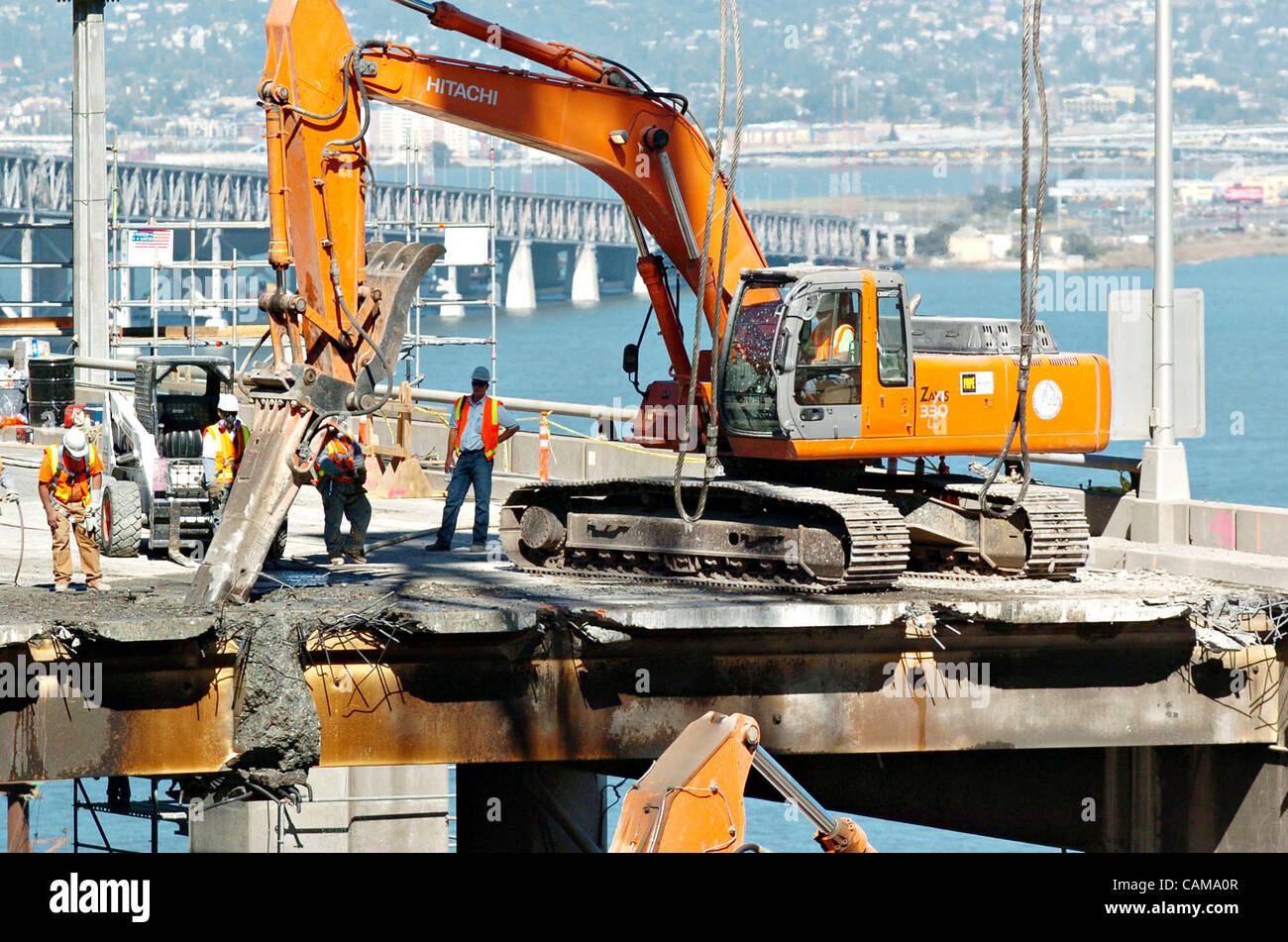 Construction workers from CC Myers Inc. demolish a section of the Bay ...