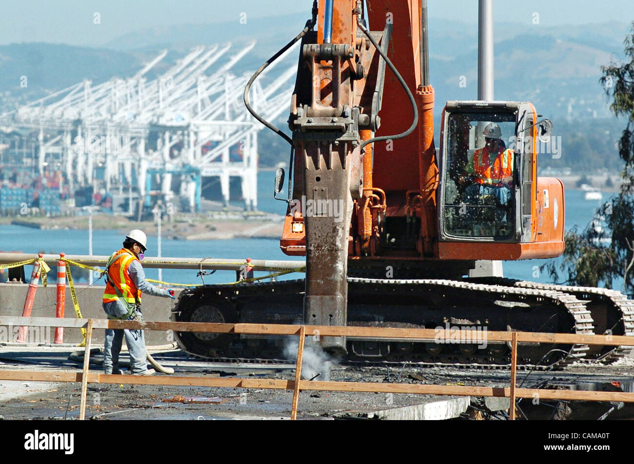 Construction workers from CC Myers Inc. demolish a section of the Bay ...