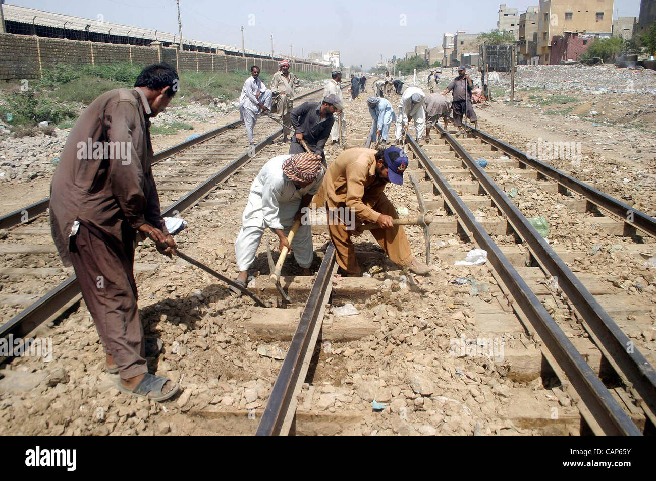 Labors repair railway tracks under the supervision of railways ...