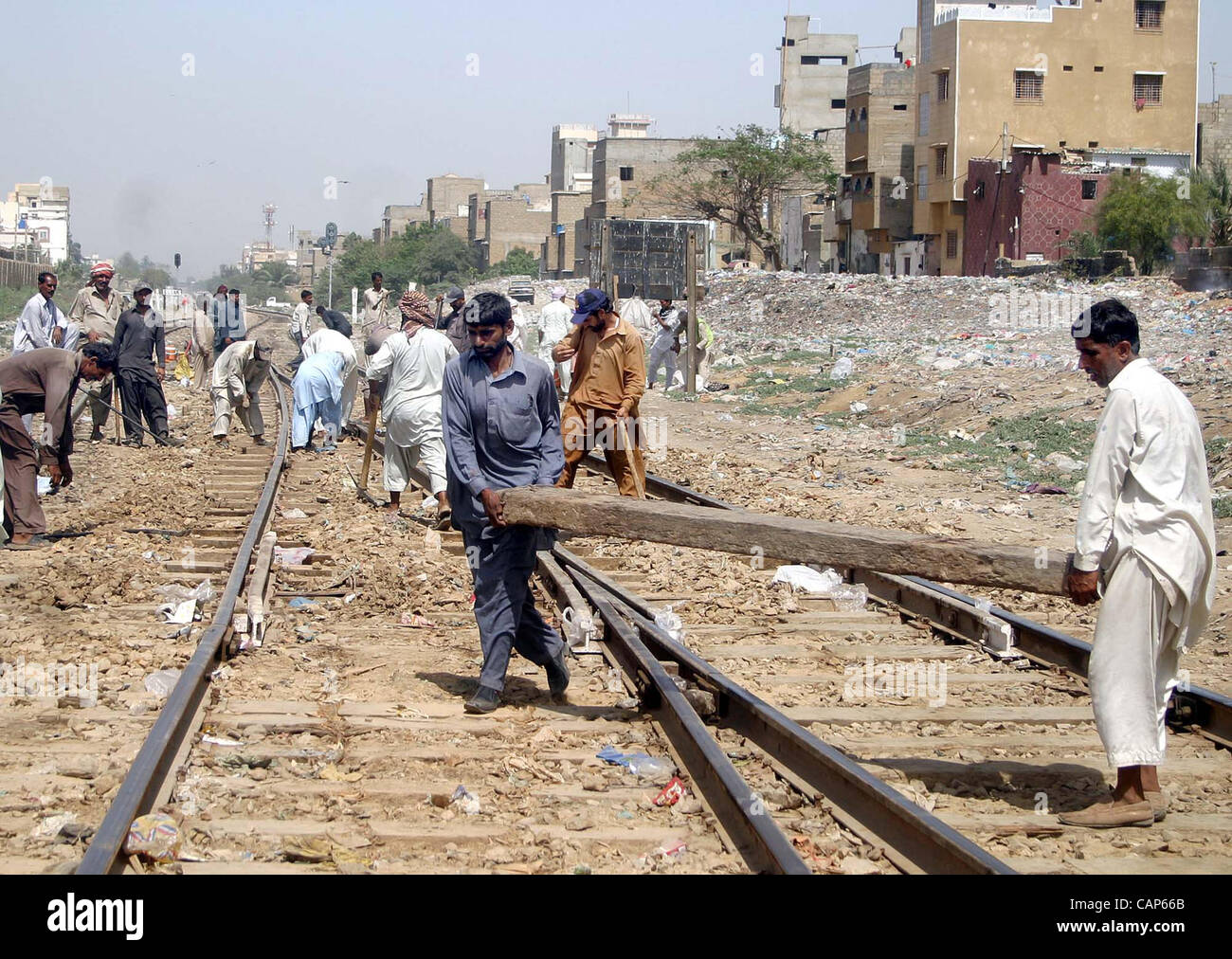 Labors repair railway tracks under the supervision of railways ...