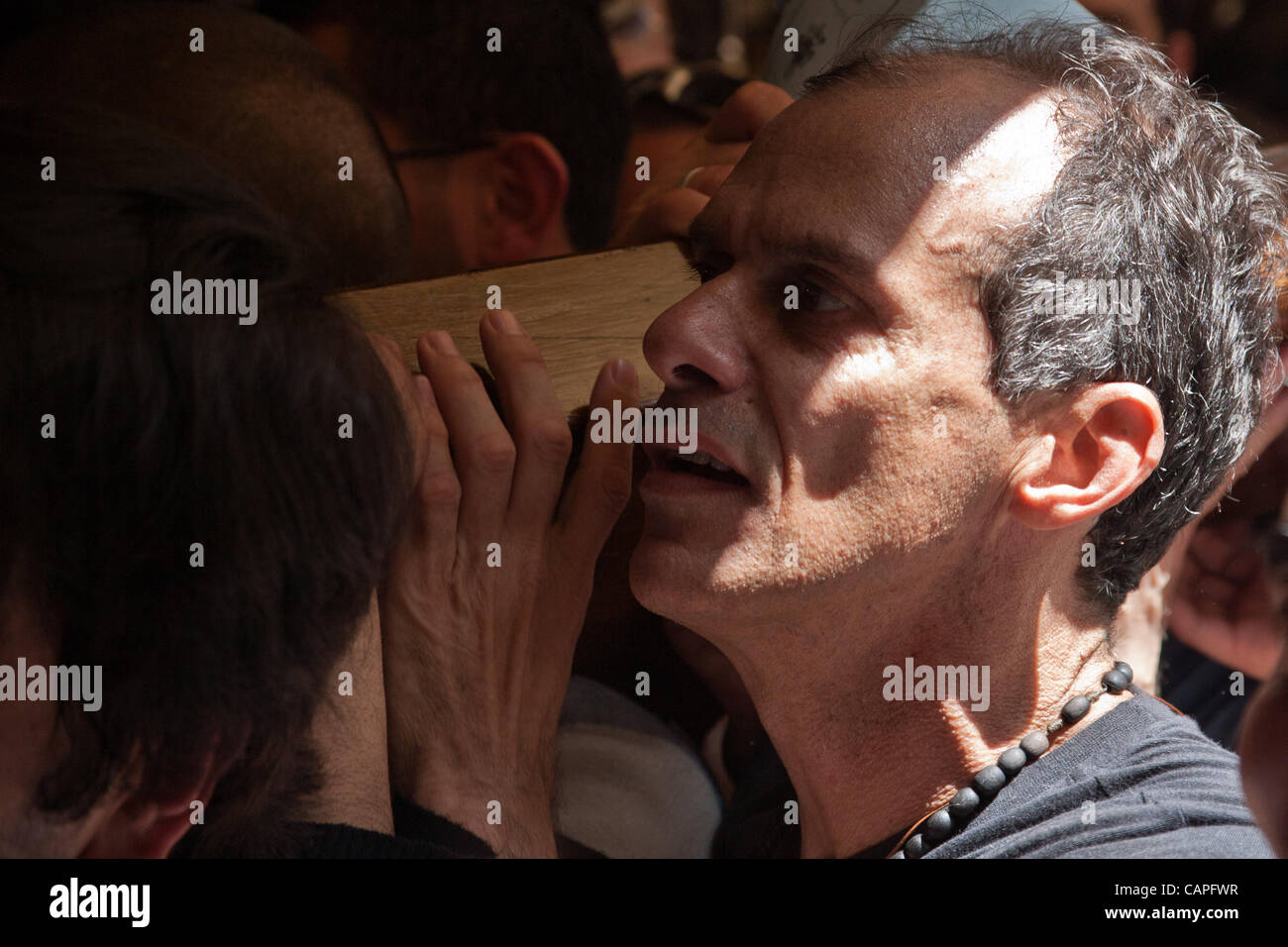 A man bears a heavy cross on his shoulder as thousands of Christian ...
