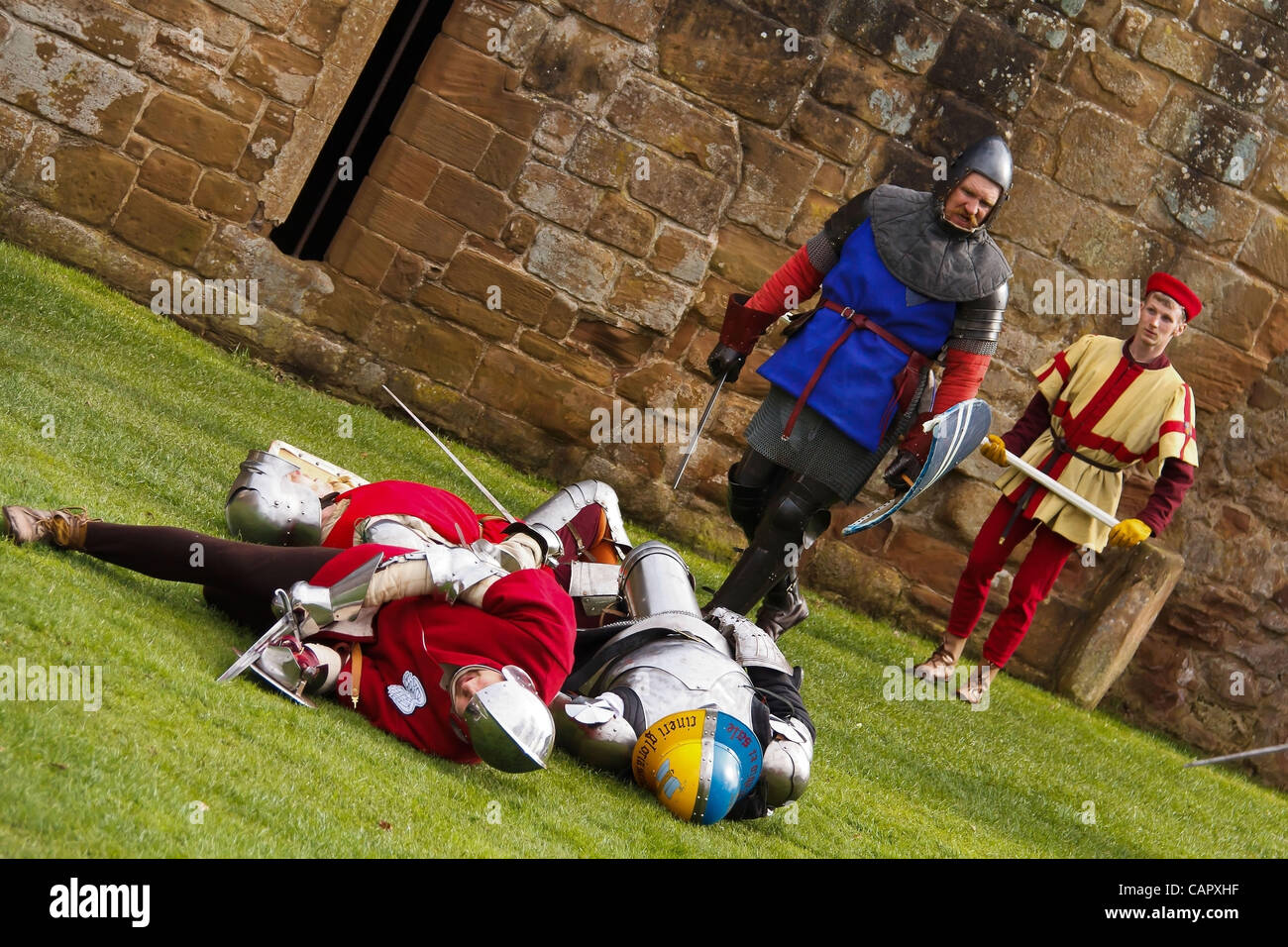 A knights from blue team stands upon two defeated knights during the ...