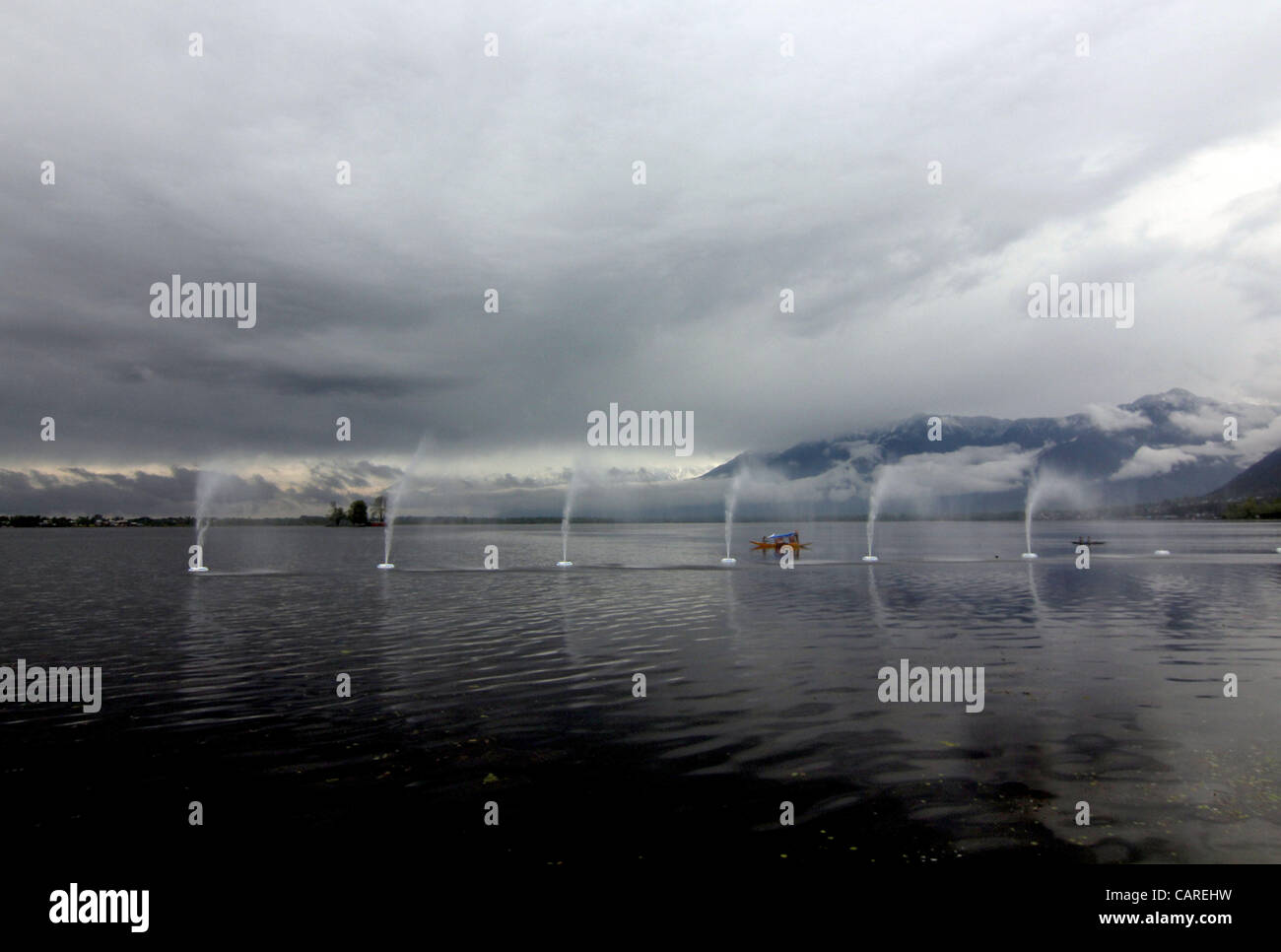 A Kashmiri boatman rows his boat during spring rain fall on Dal lake in ...