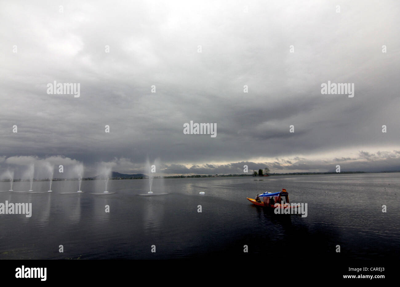 A Kashmiri boatman rows his boat during spring rain fall on Dal lake in ...