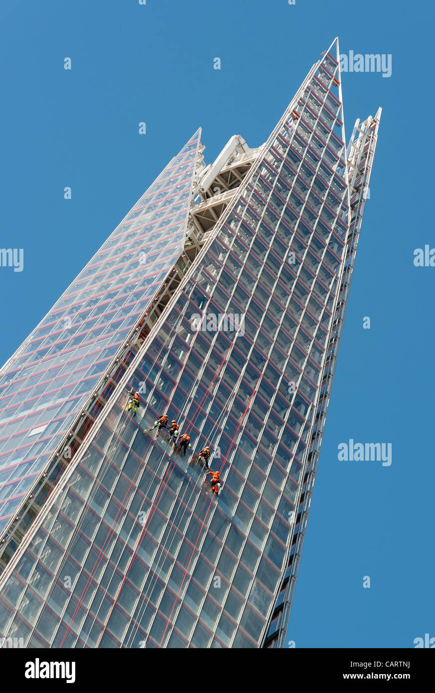 An abseiling maintenance team clean and check the windows on Europe's ...