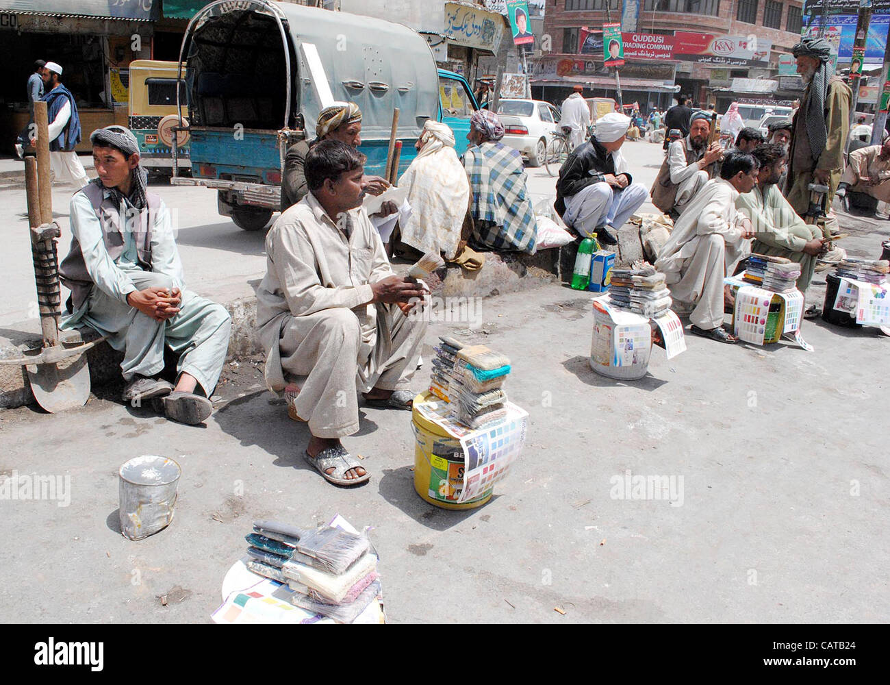 Unemployed labors sit on a footpath while they are waiting for their ...