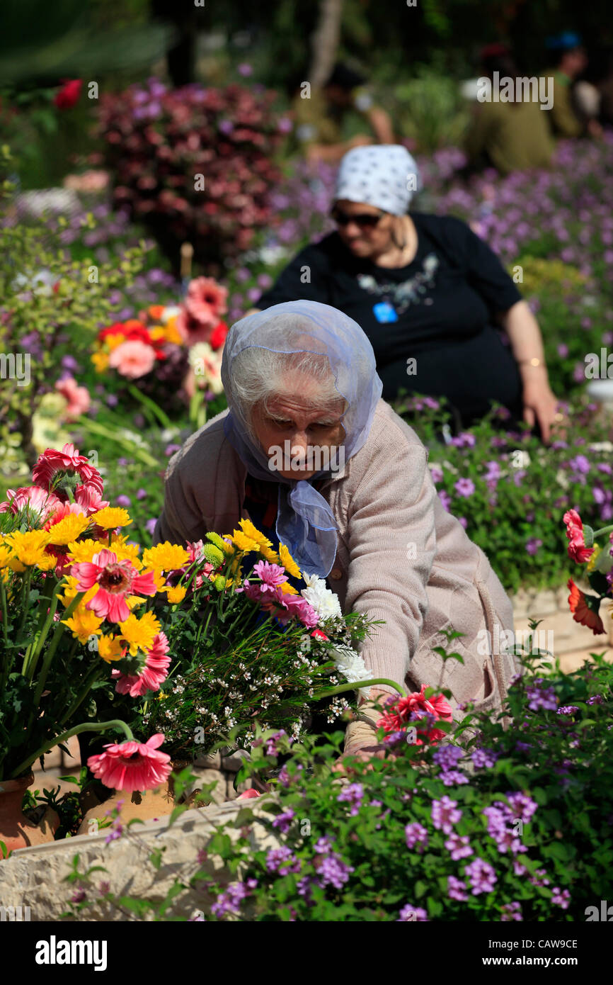 An elderly Jewish woman rubs the inscribed name on the grave stone of ...