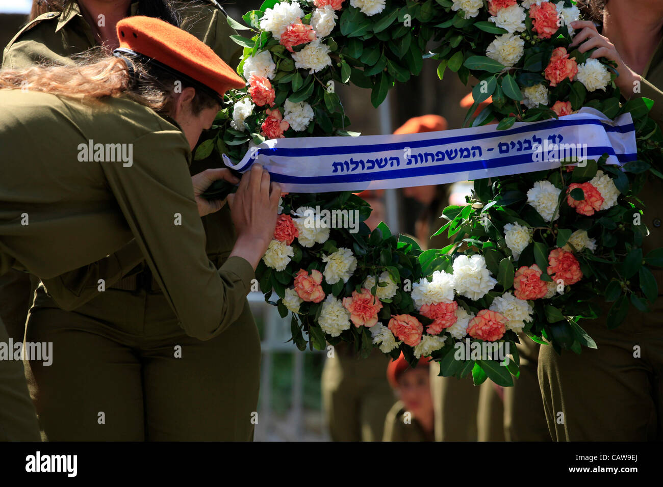 An Israeli female soldier adjusts a ribbon over a wreath during a ...