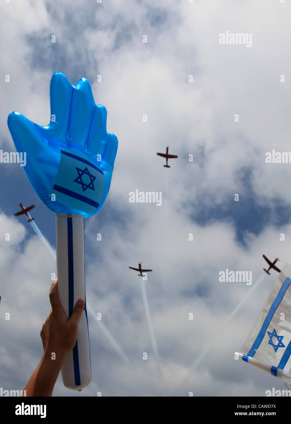 An Israeli man holds an inflatable hand bearing the Israeli flag as air ...