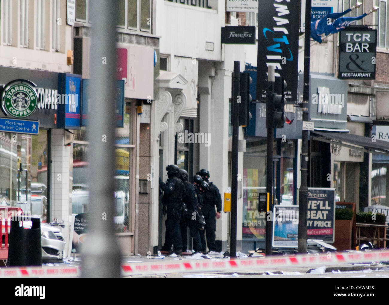 London, UK. 27/04/12. Armed police ready to storm the office and arrest ...