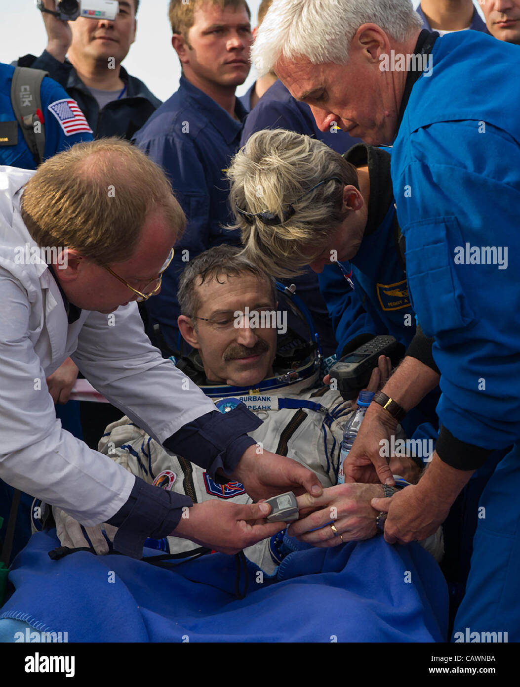 Expedition 30 Commander Dan Burbank, center, is attended to by his ...