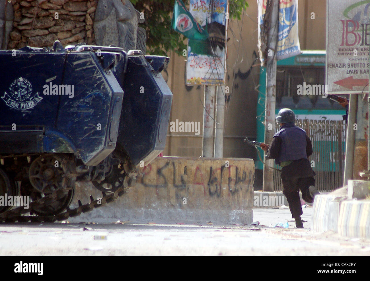 A policeman with a police armored personnel carrier (APC) enters a ...