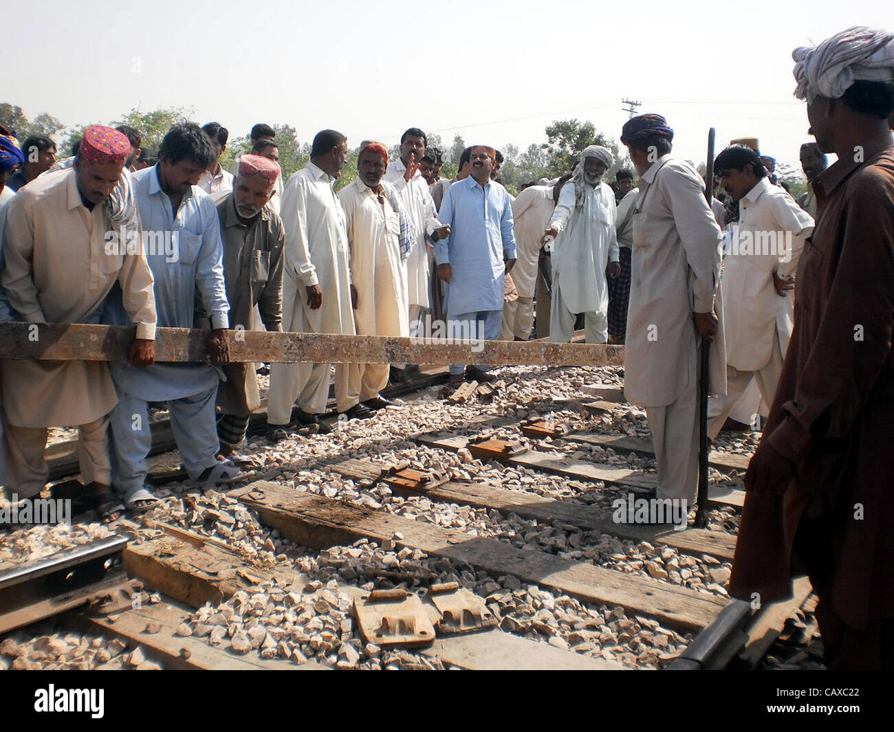 Railway workers repair a damaged portion of railway track which was ...