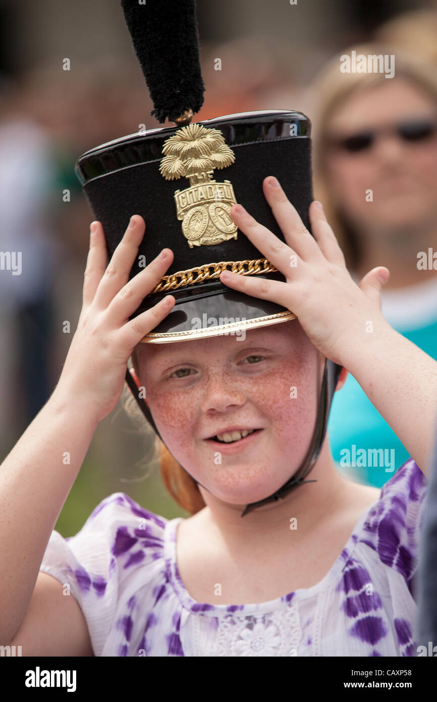 A young girl tries on the hat of her brother who graduated from the ...