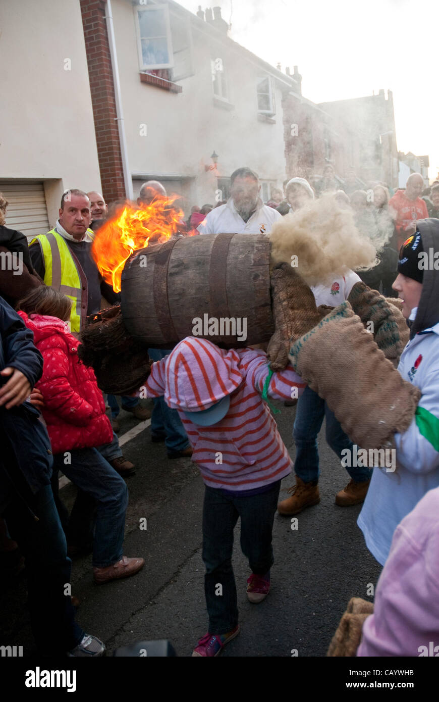A young barrel roller runs through the crowd with a burning barrel at ...