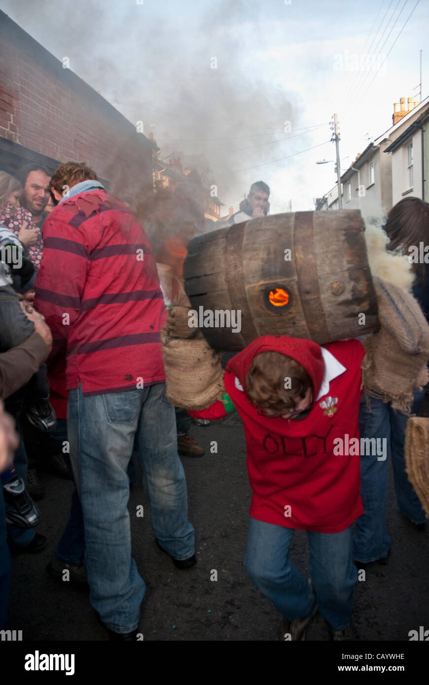 A young barrel roller runs through the crowd with a burning barrel at ...