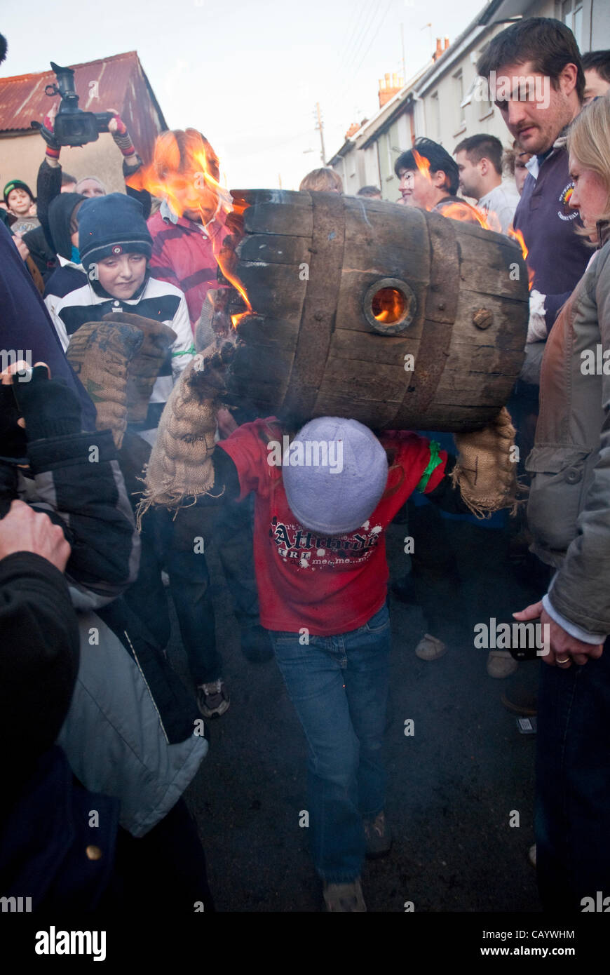 A young barrel roller runs through the crowd with a burning barrel at ...
