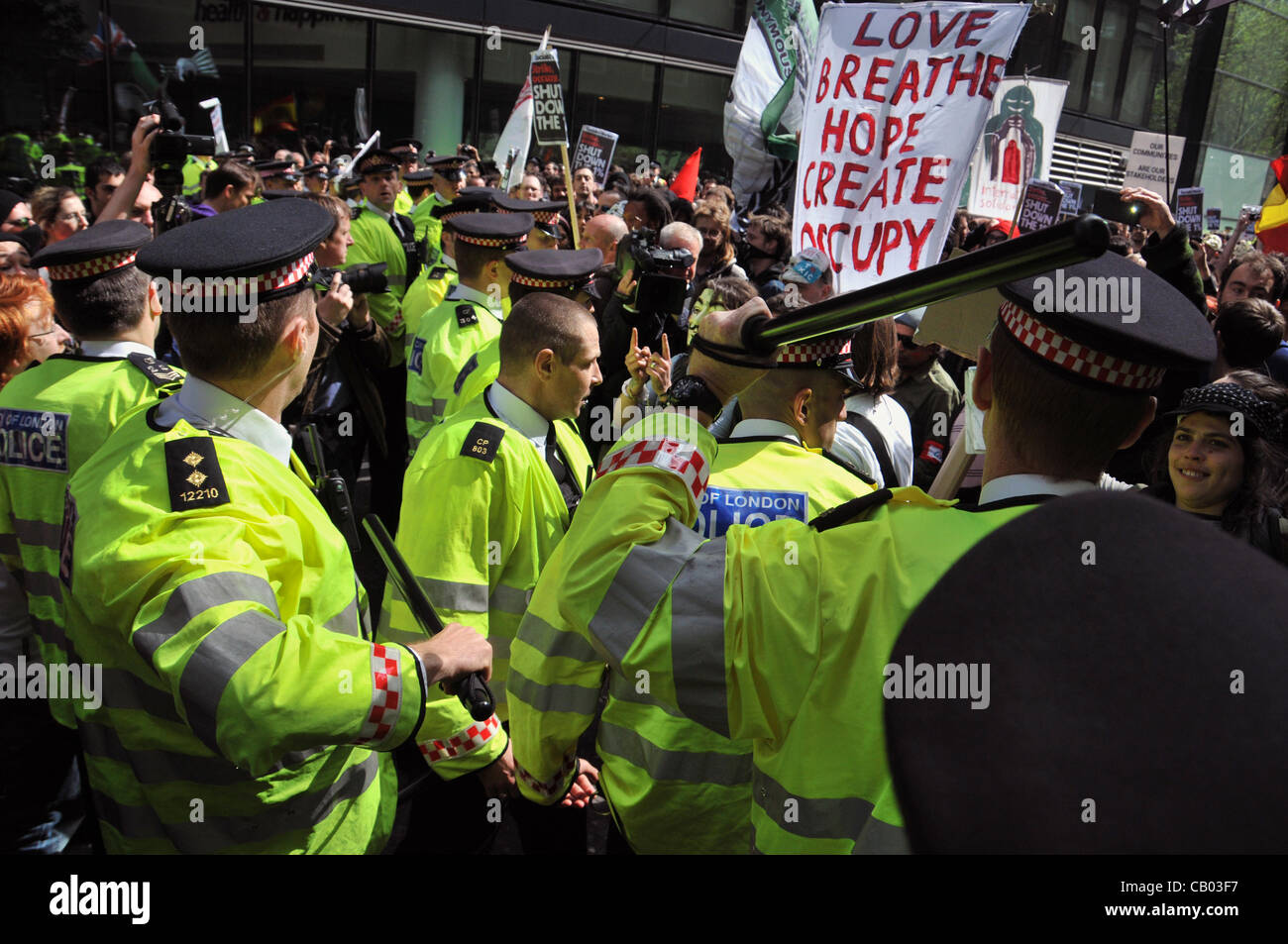 Police officers with batons raised hold the line against Occupy London ...