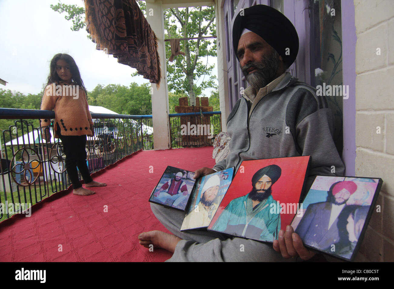 A Kashmiri Sikh hold photographs of thier relatives who were killed ...