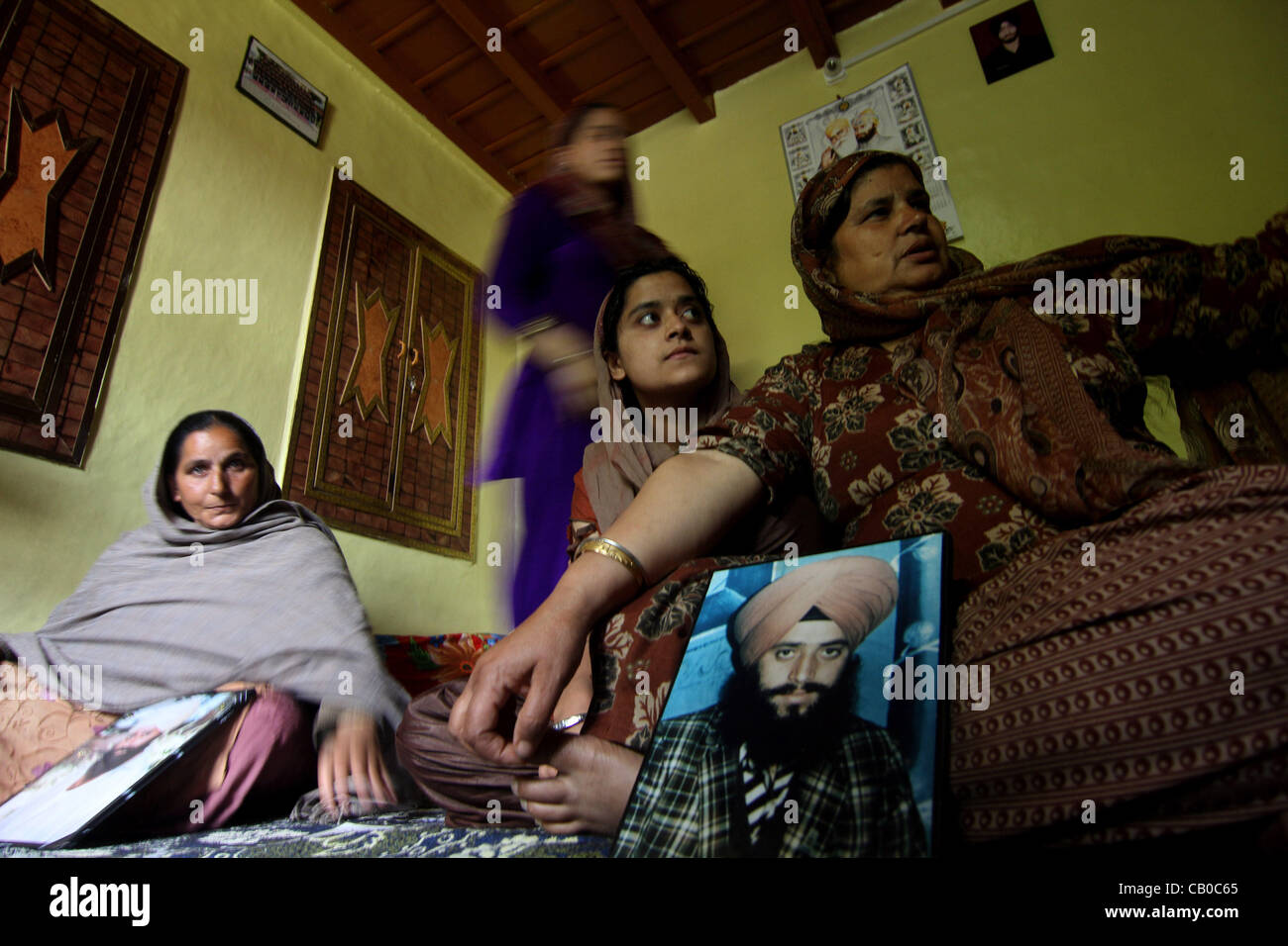 A Kashmiri Sikh famliy hold photograph of thier relative who was killed ...