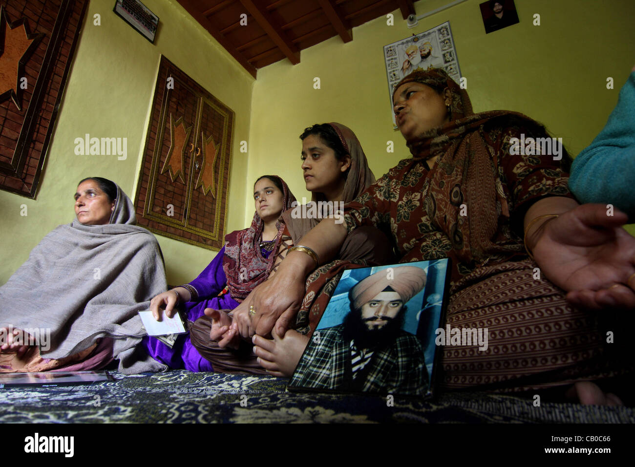 A Kashmiri Sikh famliy hold photograph of thier relative who was killed ...