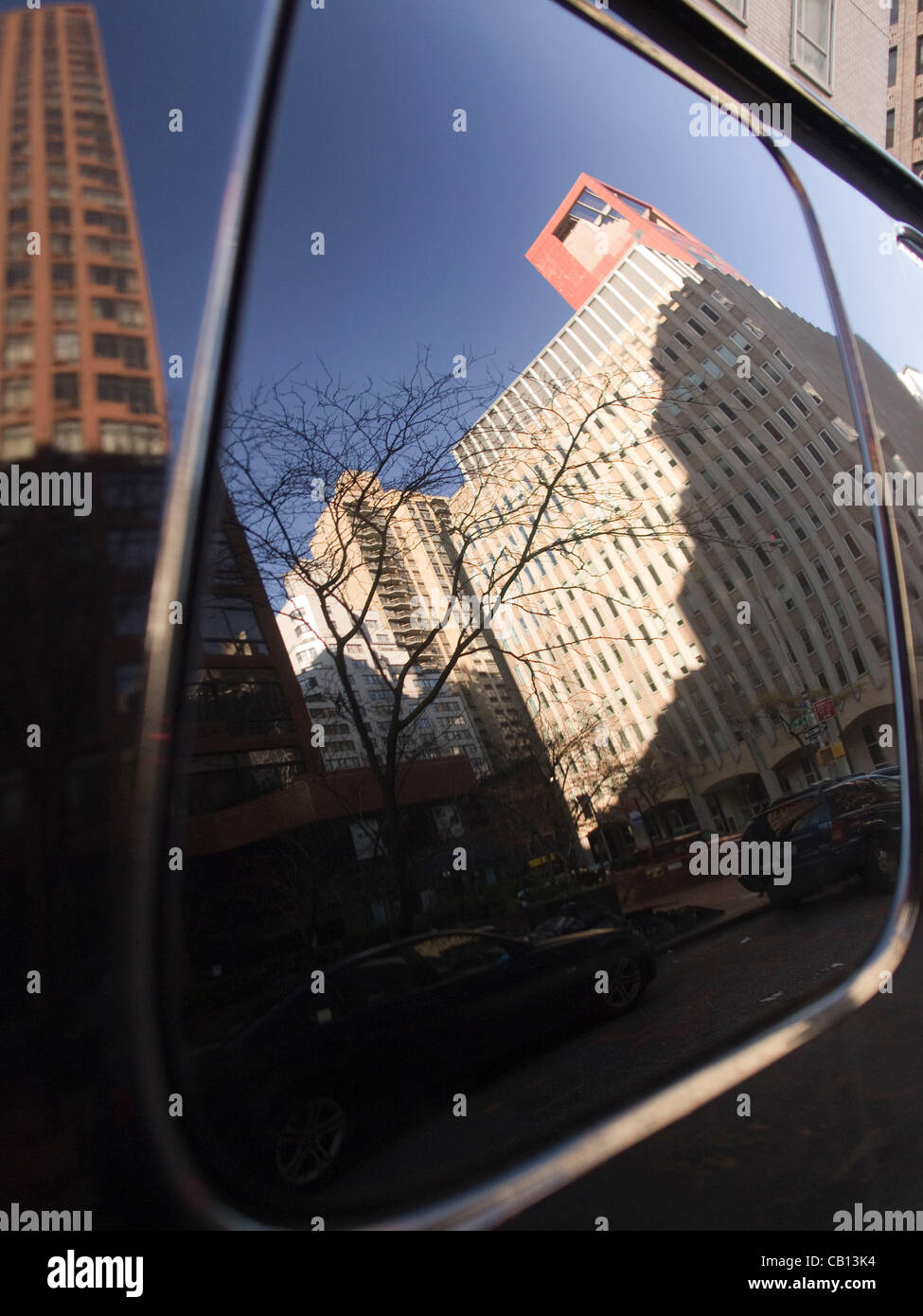 Various city buildings cast a reflection in a car window in New York ...