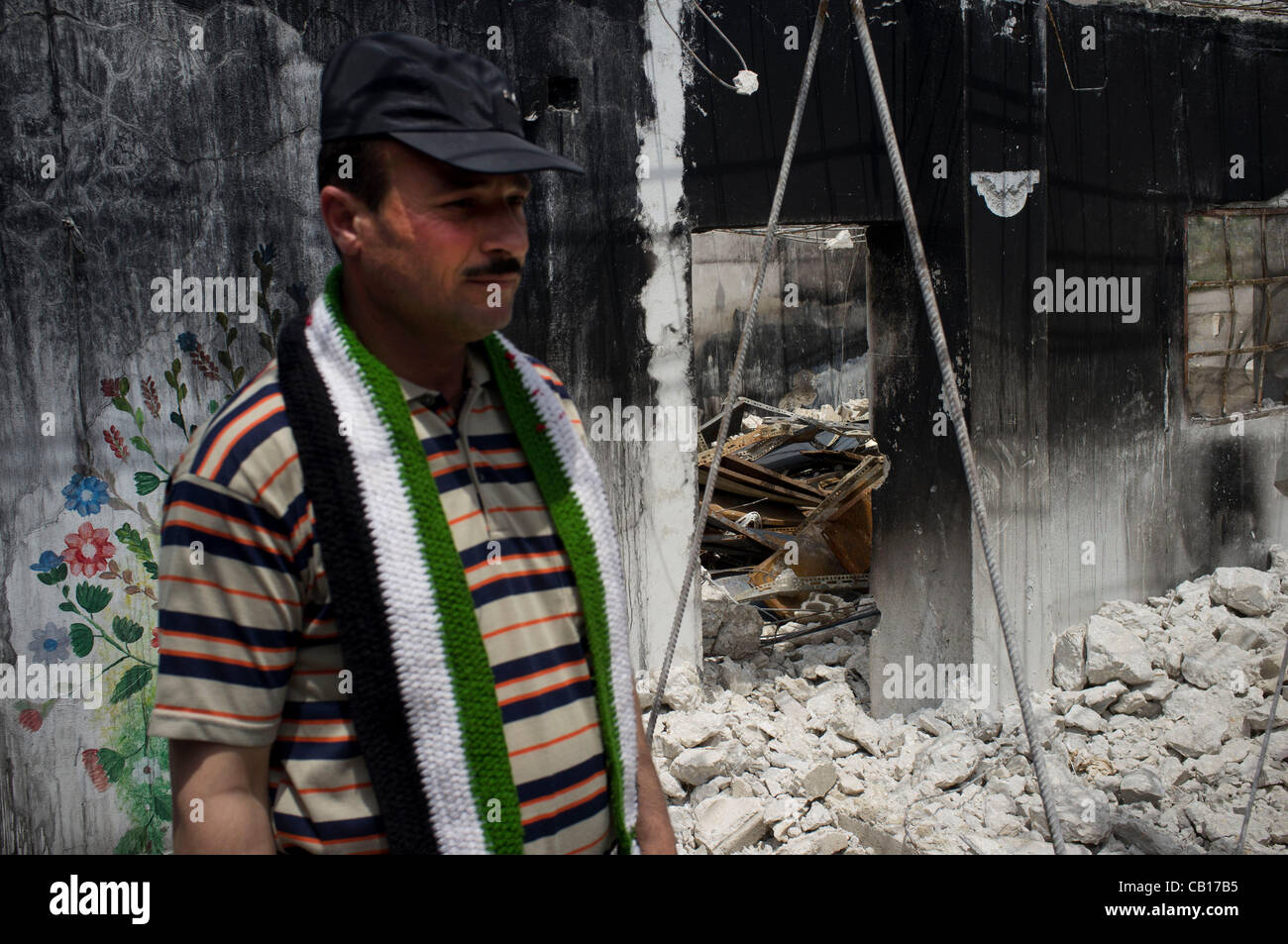 A man (name withheld) stands outside the remains of his house and place ...