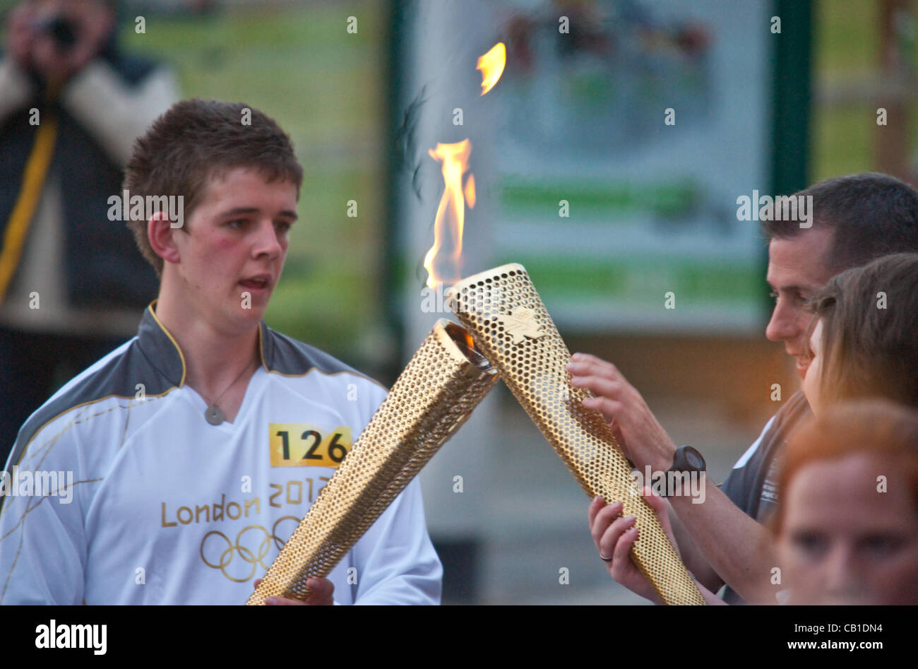 The Olympic Torch relay hands over from one runner to another, with the ...