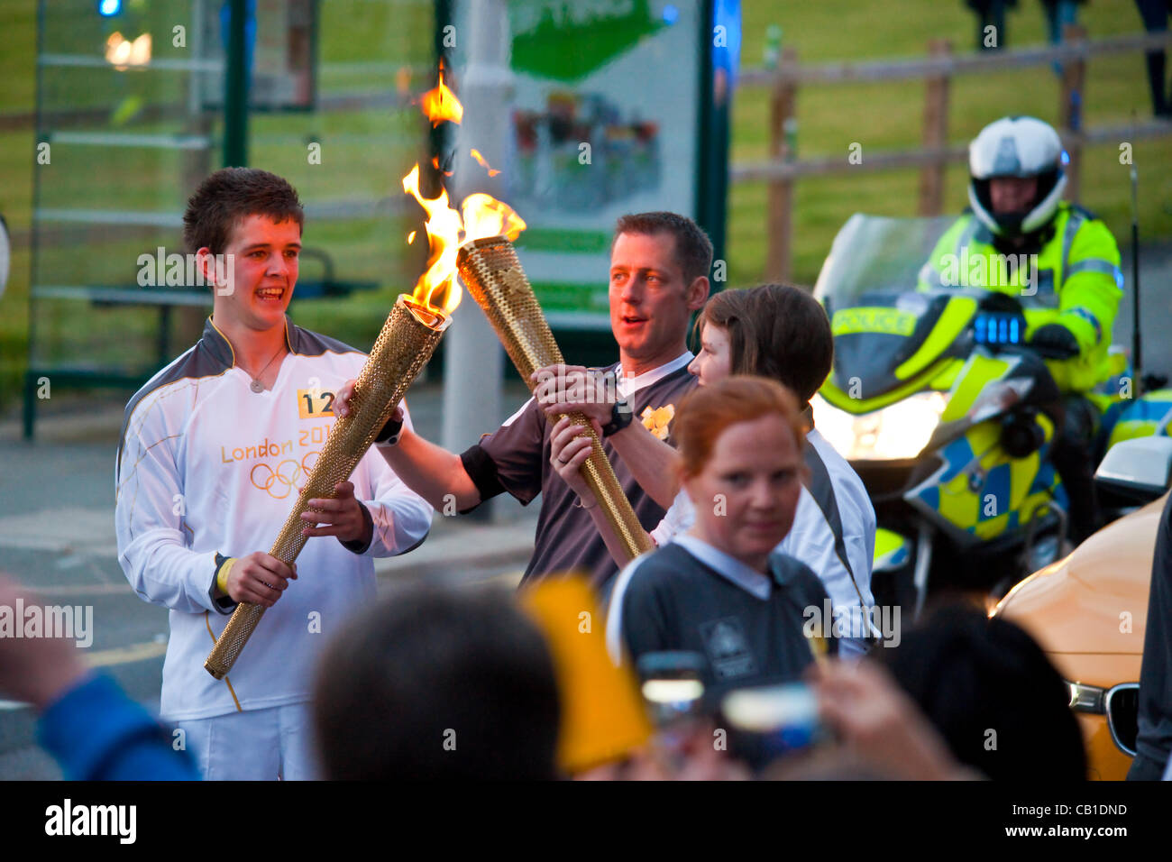 The moment one torch lights another in the Olympic torch relay. The ...