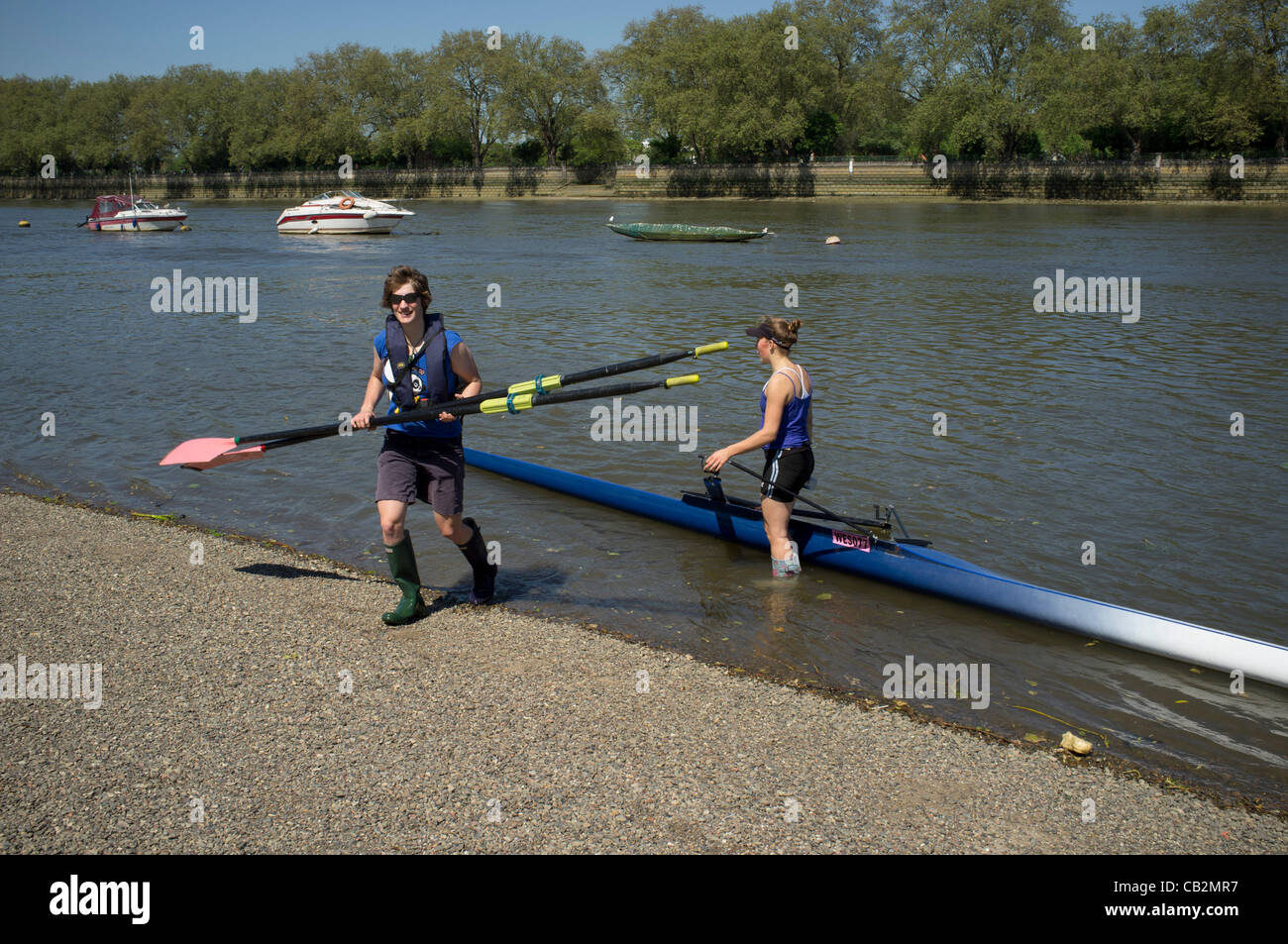 25 May, 2012. Putney London, UK. Two Female rowers carry a rowing boat ...