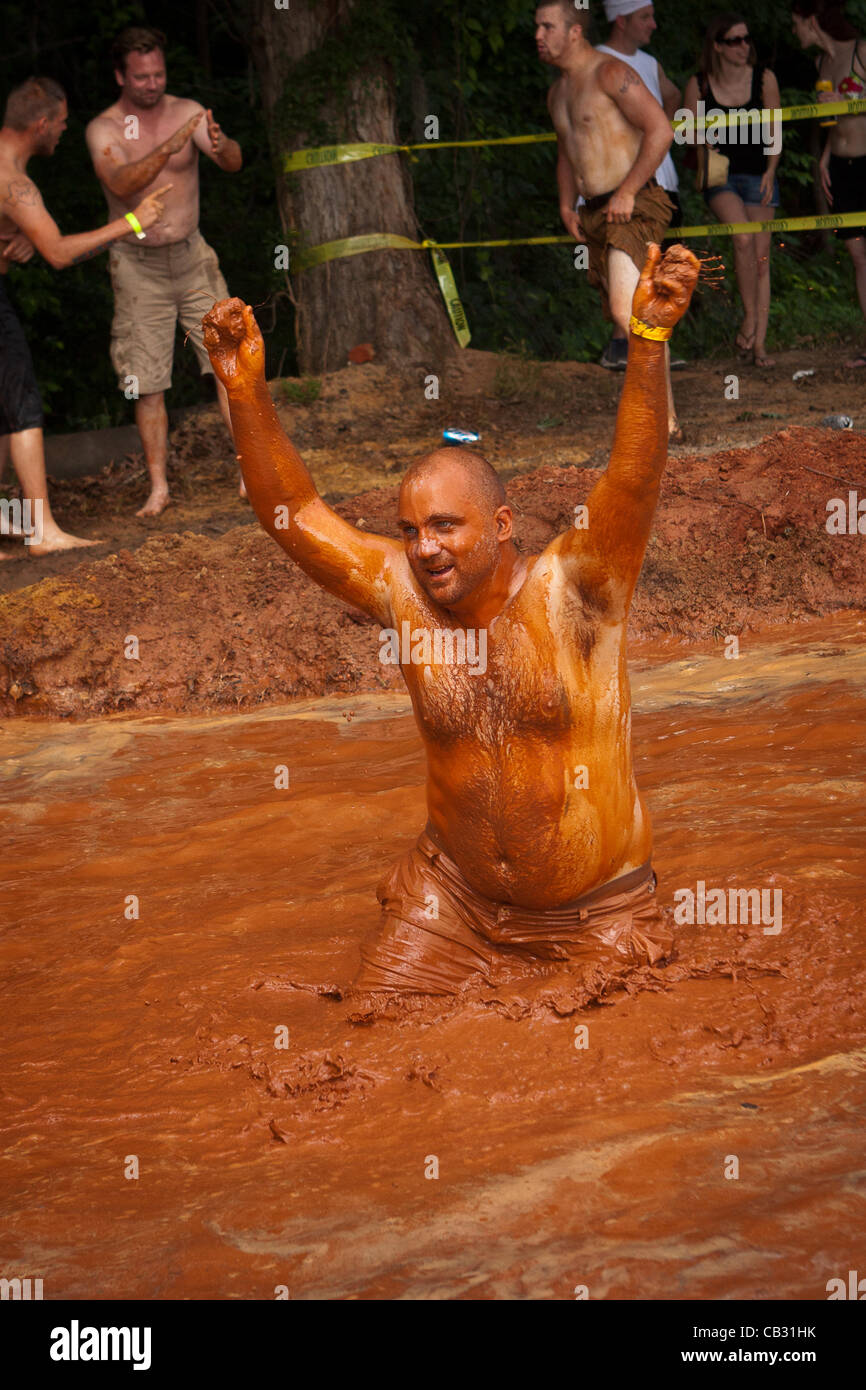 A competitor celebrates after diving into a pool of mud during the Mud ...