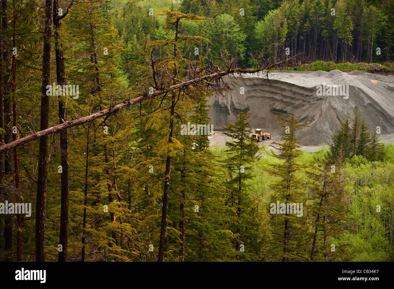 Sitka, Alaska 27 May 2012 Machinery in rock quarry at the edge of rain ...