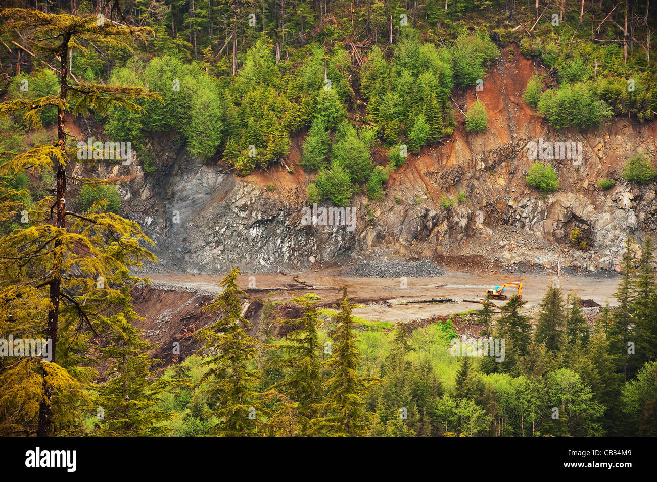 Sitka, Alaska 27 May 2012 Machinery in rock quarry at the edge of rain ...